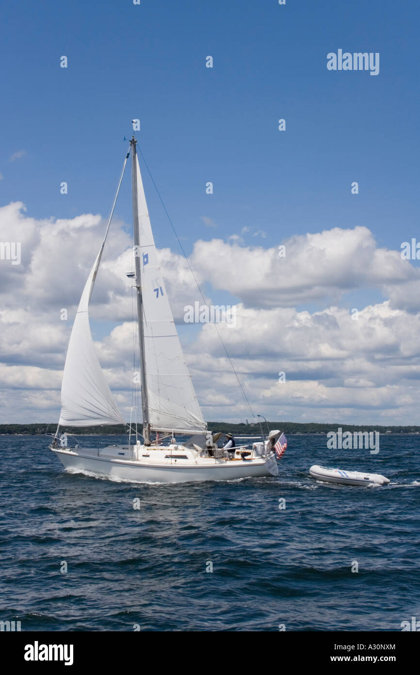 A cruising sloop under sail with a reefed jib in the waters of ...