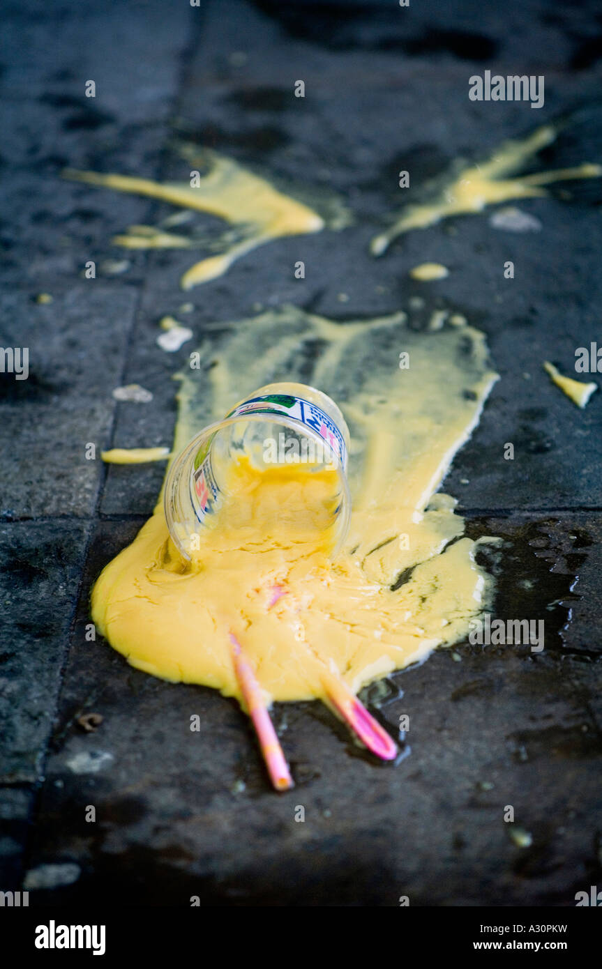 A milkshake style drink discarded on a pavement Stock Photo - Alamy