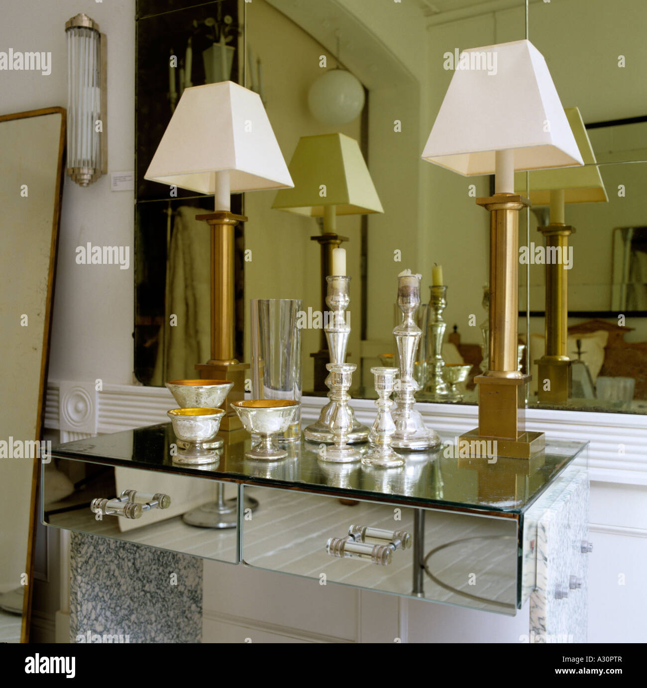 Matching lamps on mirrored table in hallway Stock Photo - Alamy