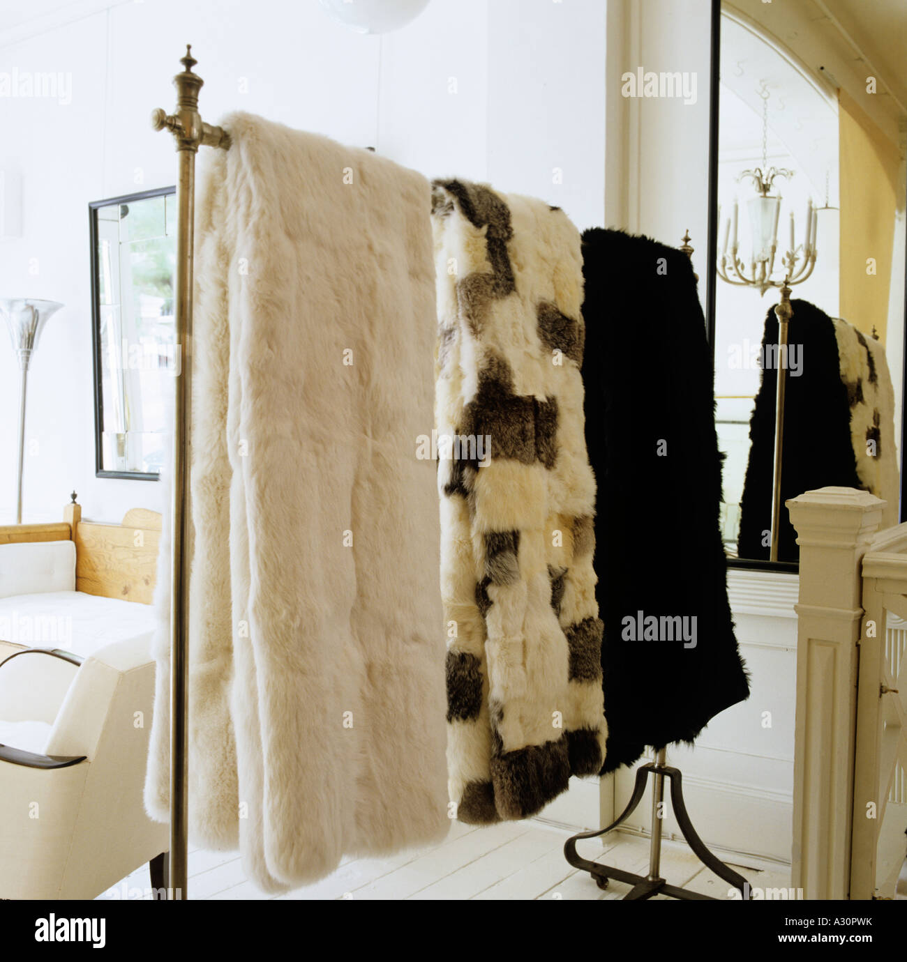 Contrasting fur throws hanging on a brass clothes rail Stock Photo - Alamy