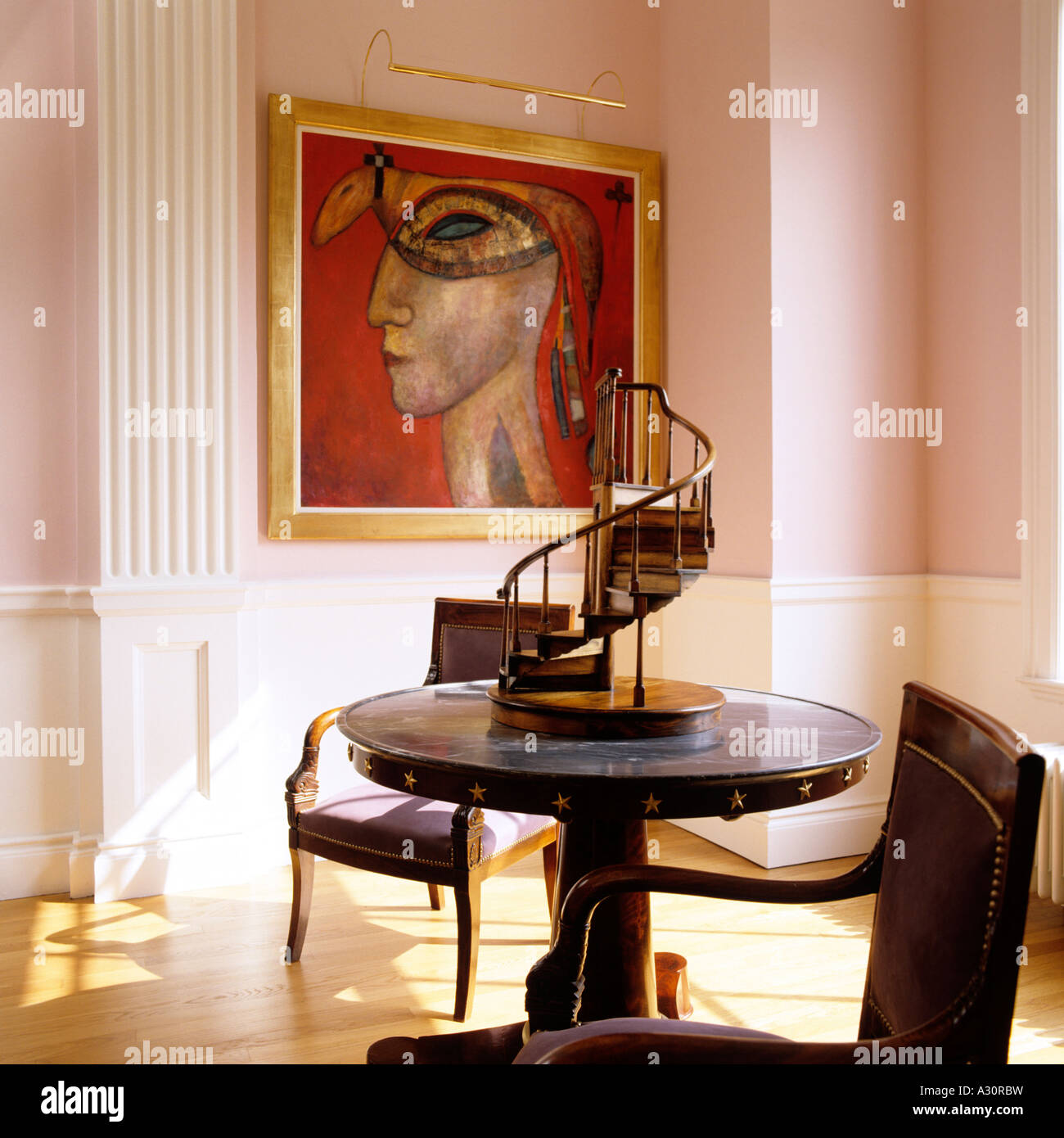 Wooden chairs at circular table with spiral step sculpture and ...