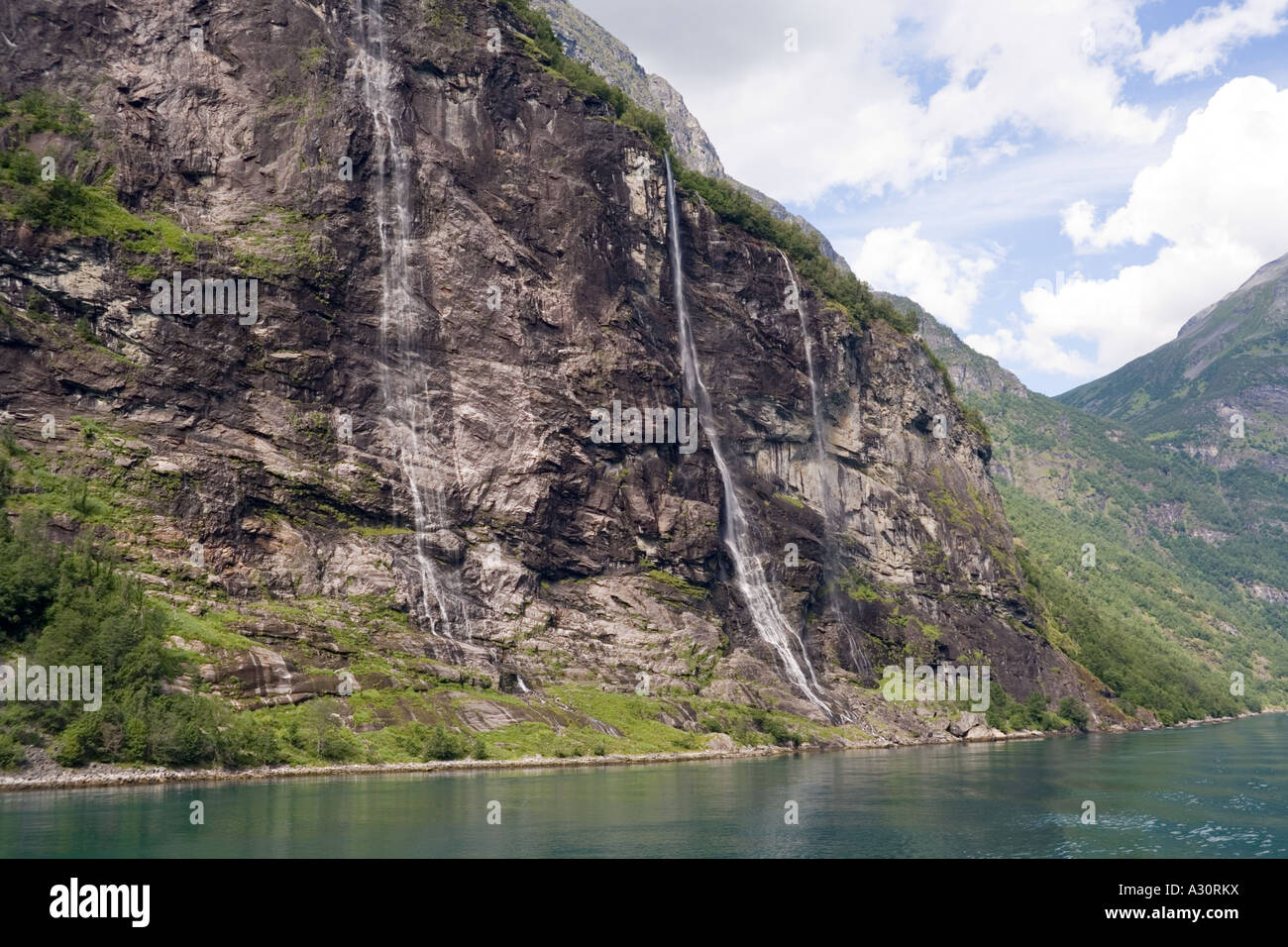 A waterfall flowing into the Geiranger Fjord Geirangerfjorden Norway ...