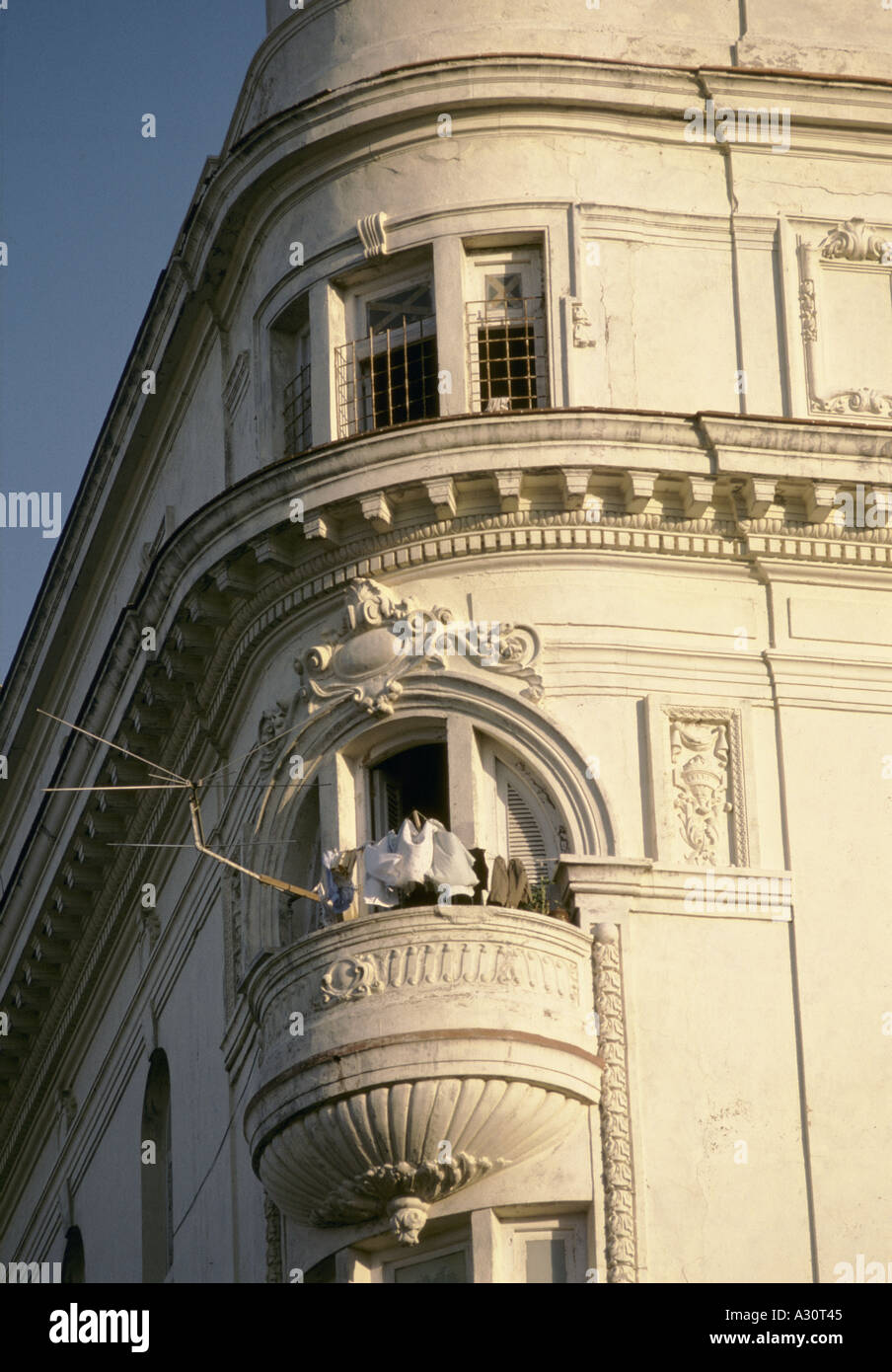 Laundry drying on washing line off a balcony on the corner of an white ...