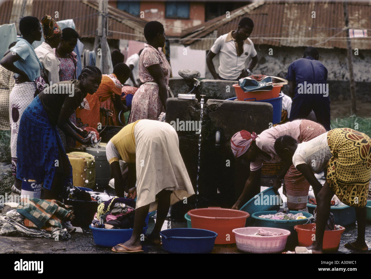 women bending over washing laundry in plastic basins kenya Stock Photo ...