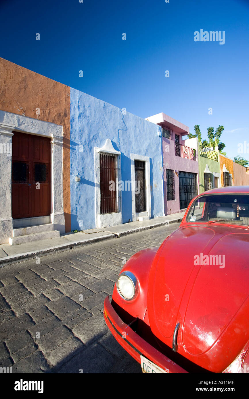 Red Volkswagen Beetle and coloured Spanish Colonial buildings in ...