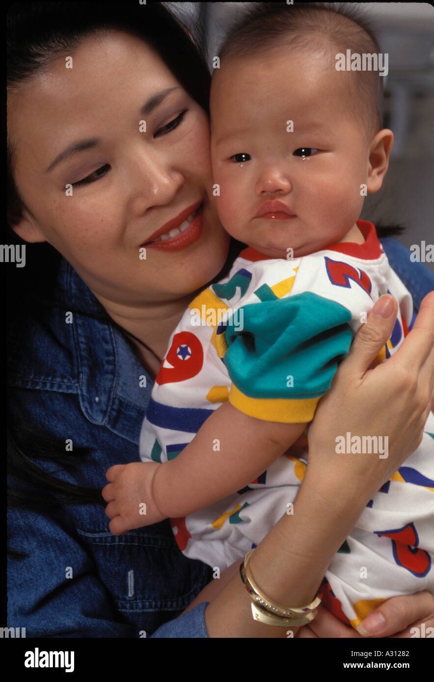 Japanese American mother comforts crying baby daughter Stock Photo - Alamy