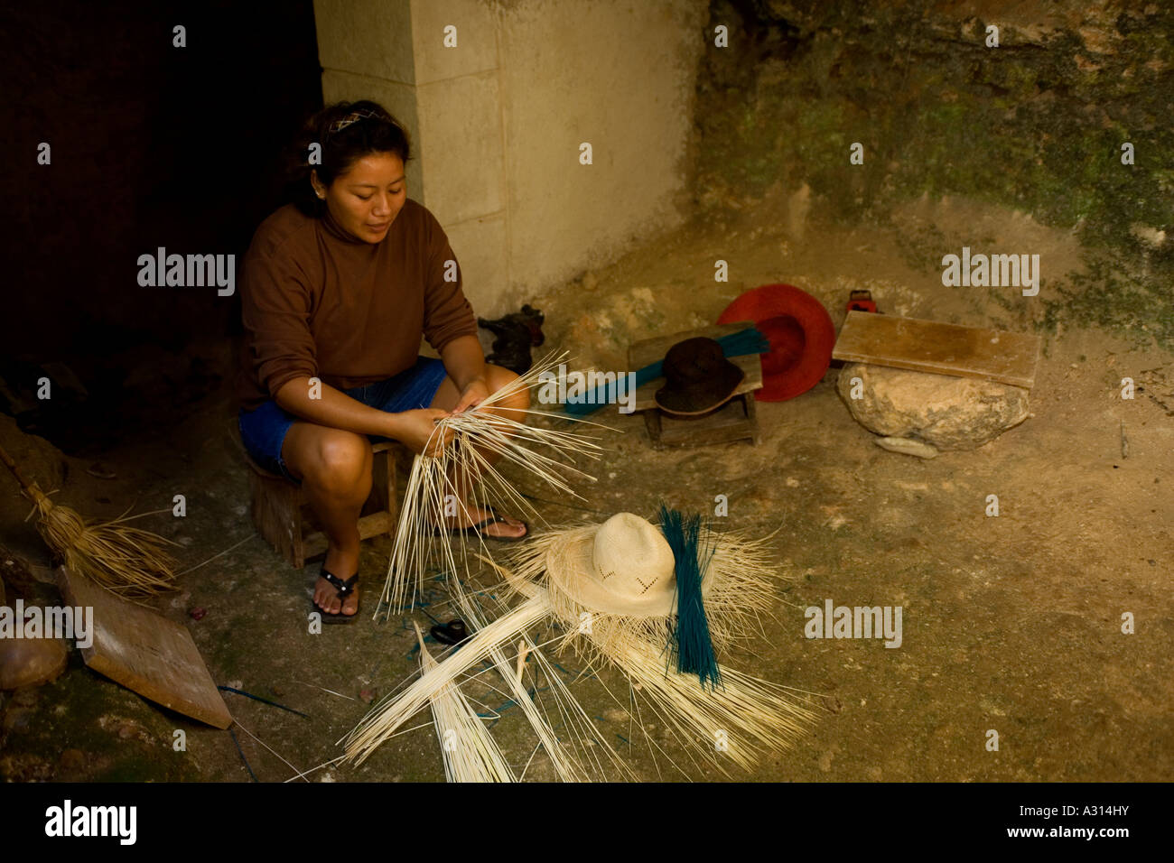 Woman braiding the famous panama straw hats in a traditional cave in ...
