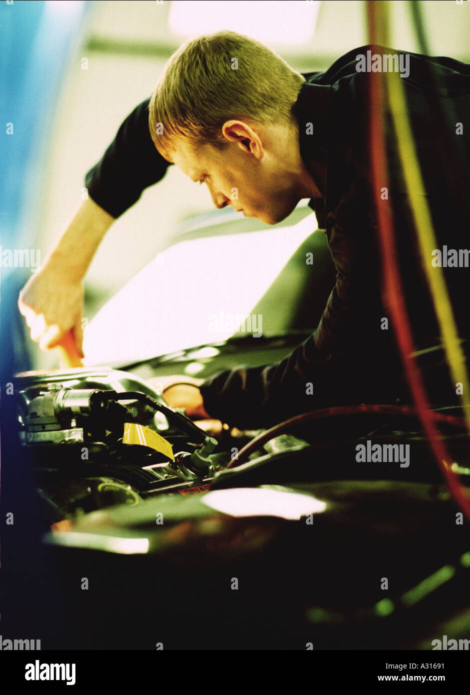 Car mechanic adjusting an engine Stock Photo - Alamy