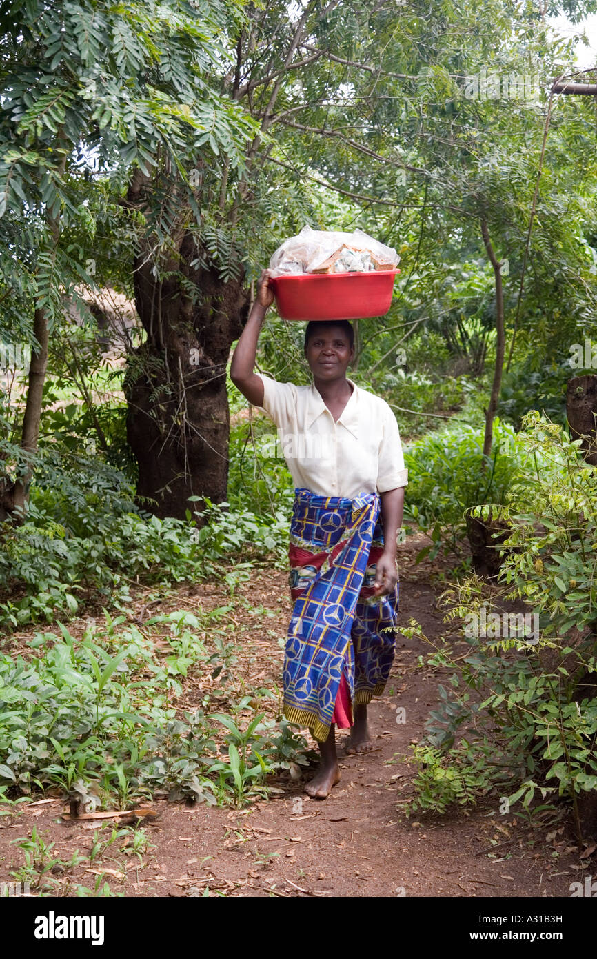 A lady carrying a bowl of bread on her head in the village of Mombala ...
