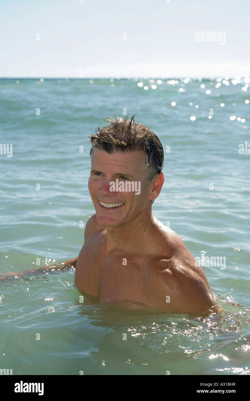 Man standing in the sea and smiling Stock Photo - Alamy