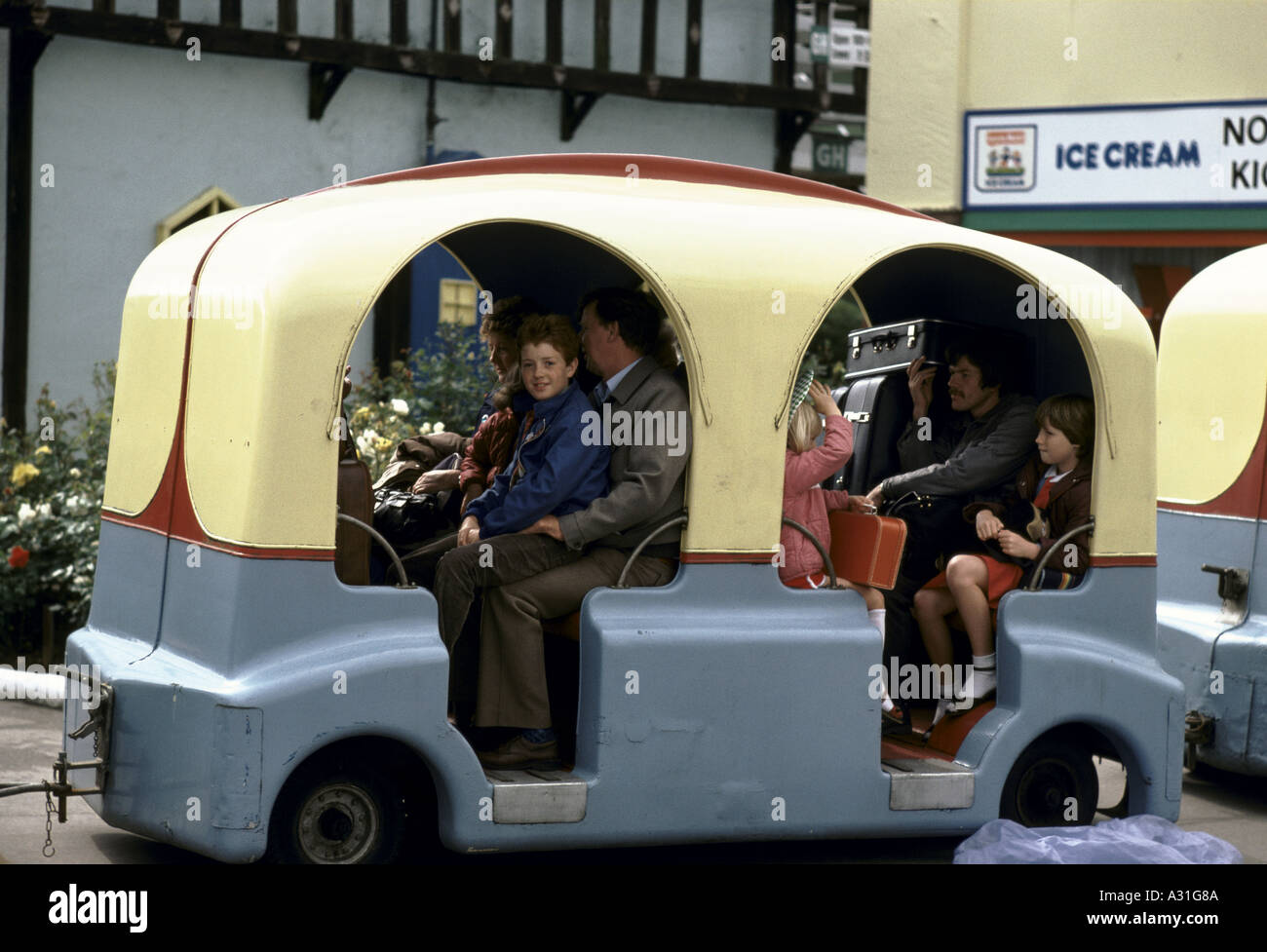 families with luggage travelling within butlins holiday camp by fancy ...