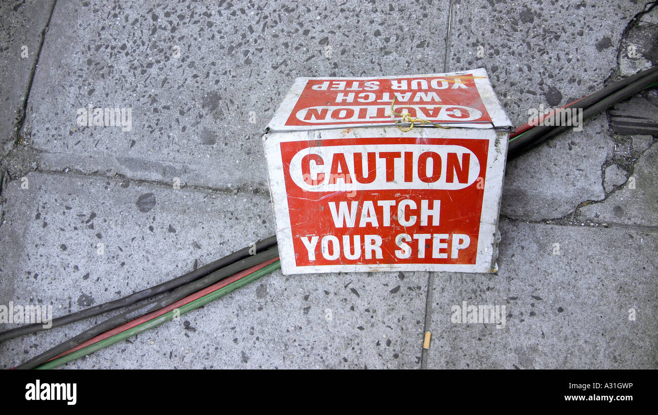 Caution sign covering electrical wires on NYC sidewalk Stock Photo - Alamy