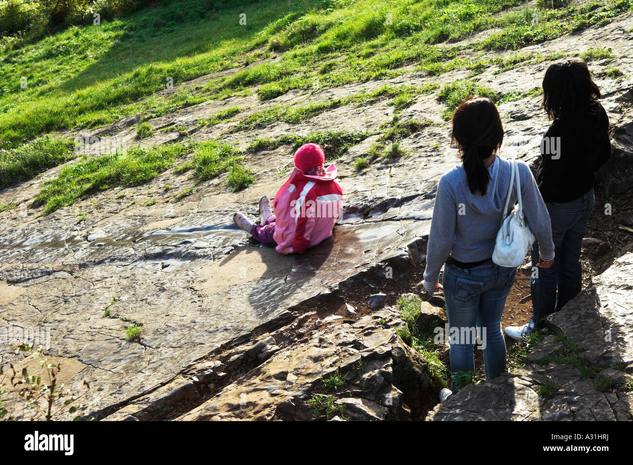 Kids using well worn natural stone slide on Clifton Down Bristol ...