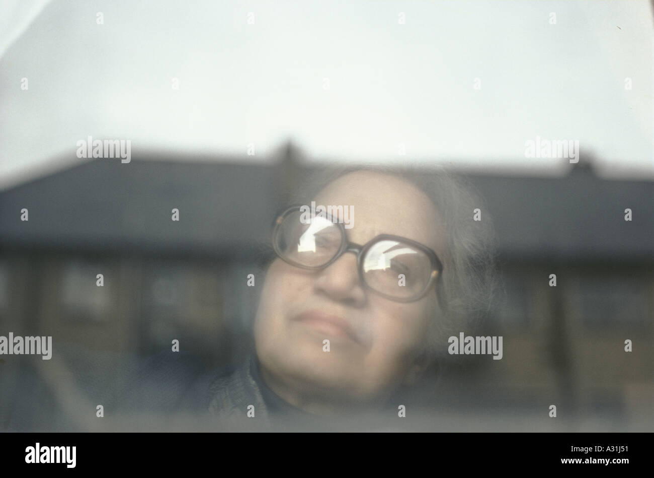old lady looking through a window with reflection of a house Stock ...