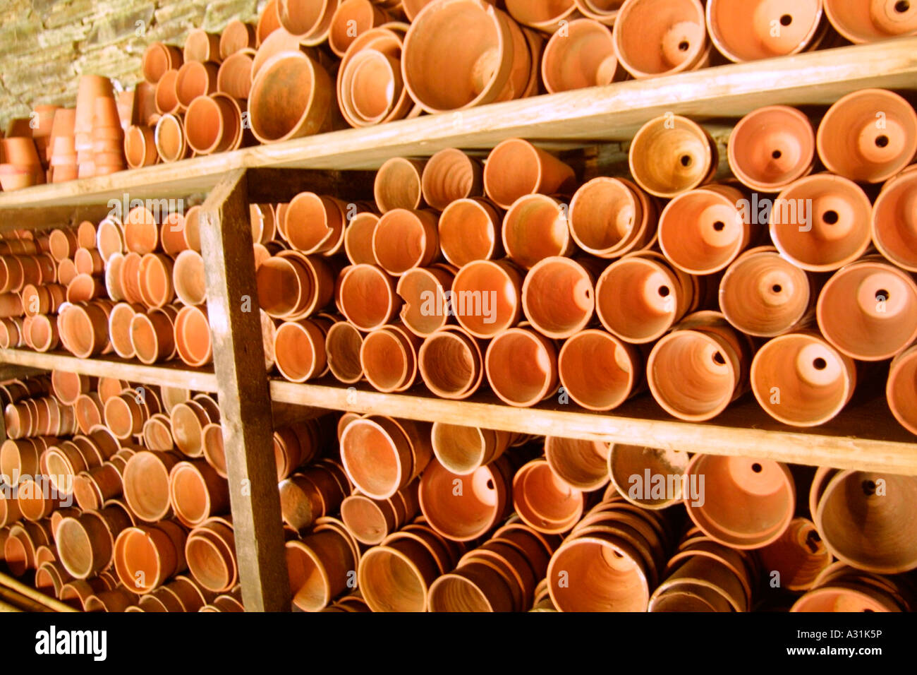 Traditional clay flower pots stacked on shelves in a garden shed Stock ...
