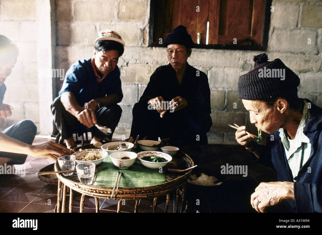 Tribesmen from the Akha tribe eating around a table together, Golden ...