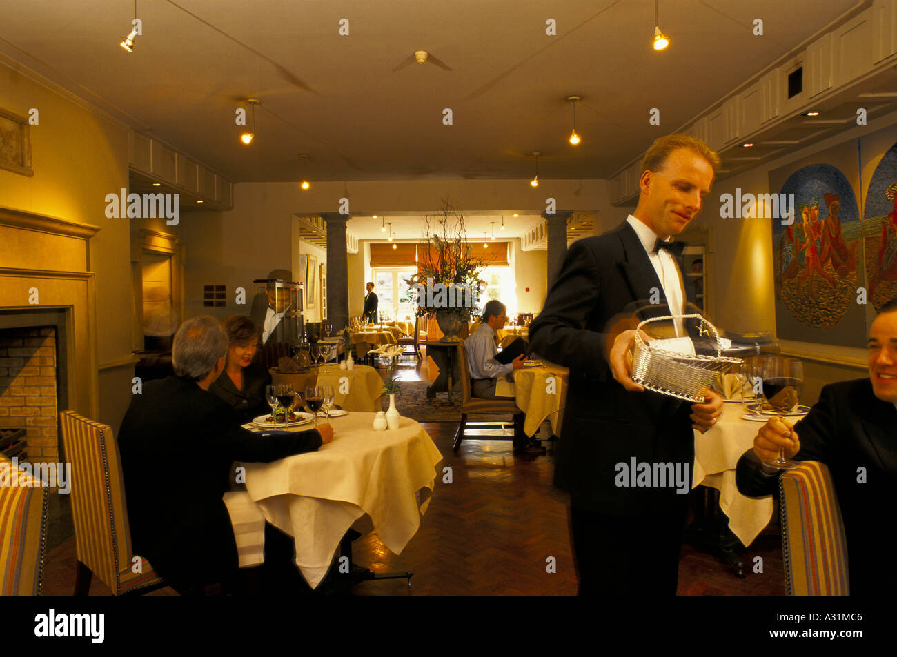 waiter serving wine to customer in restaurant Stock Photo - Alamy