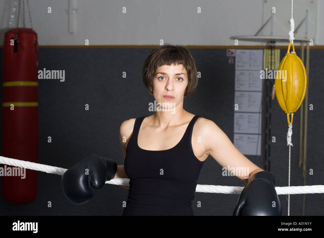 Female boxer leaning on ropes of boxing ring Stock Photo - Alamy