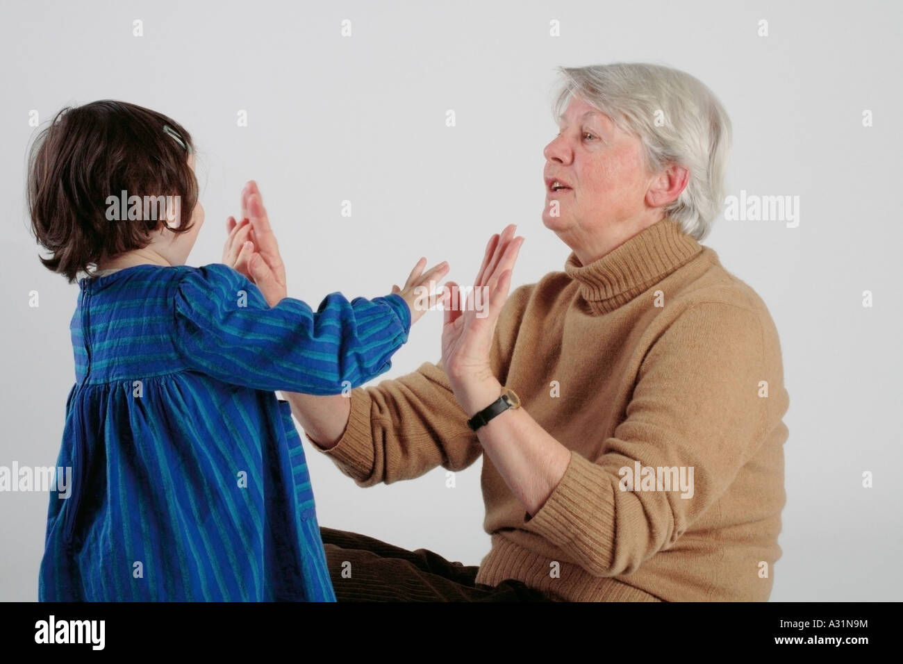 Woman clapping hands with young girl Stock Photo - Alamy