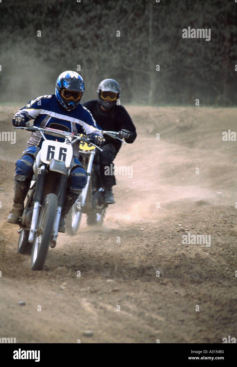 Two people racing motorcycles on dirt track Stock Photo - Alamy