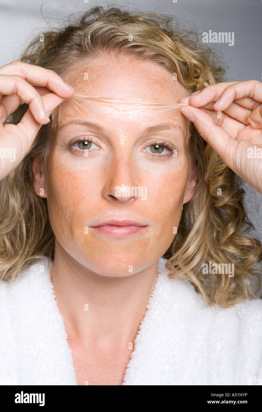 Woman peeling off face mask Stock Photo - Alamy