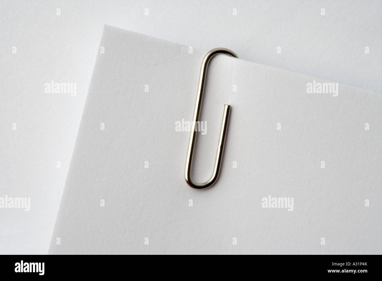 Paper clip on corner of paper Stock Photo - Alamy