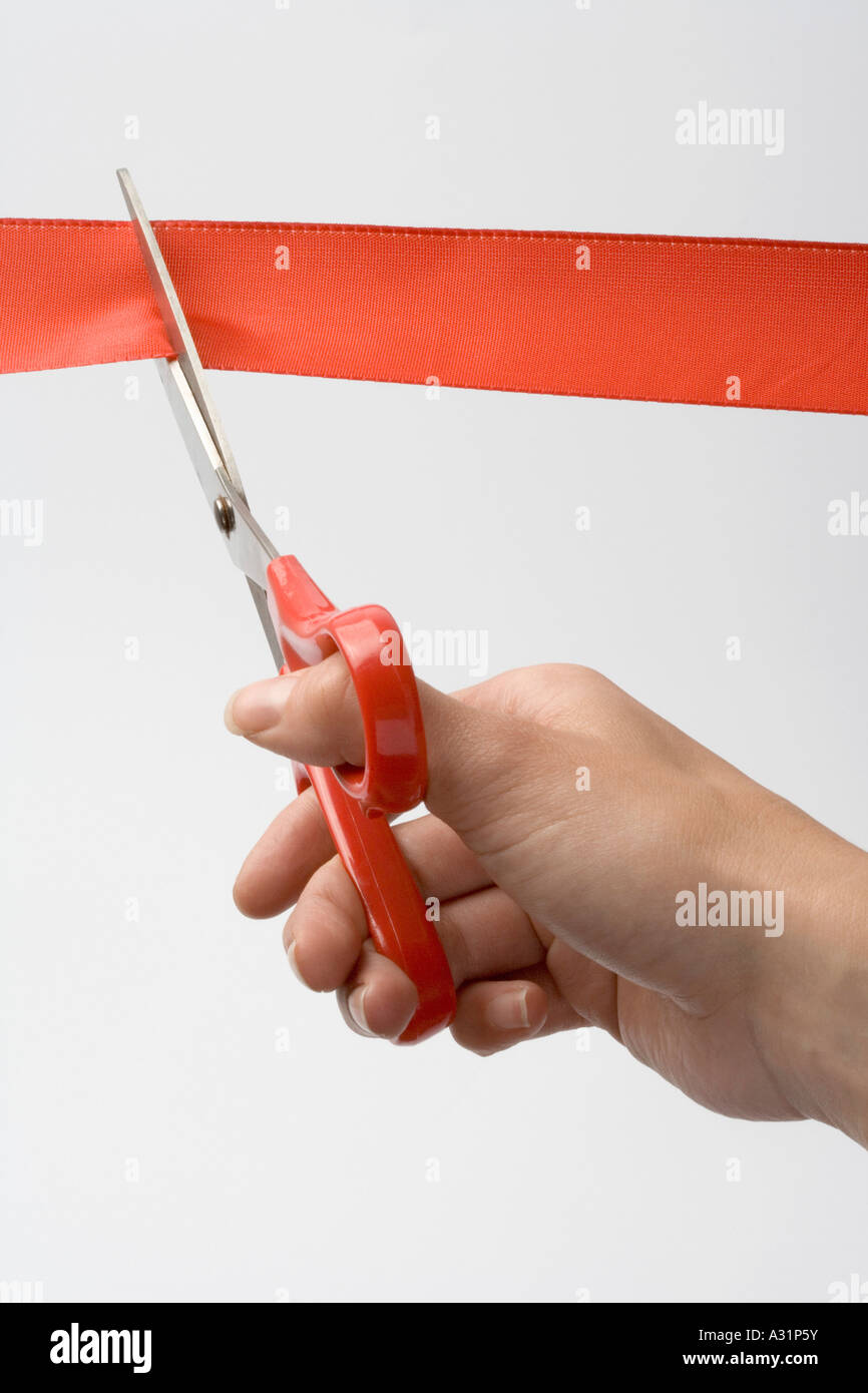 Person cutting red ribbon with scissors Stock Photo - Alamy