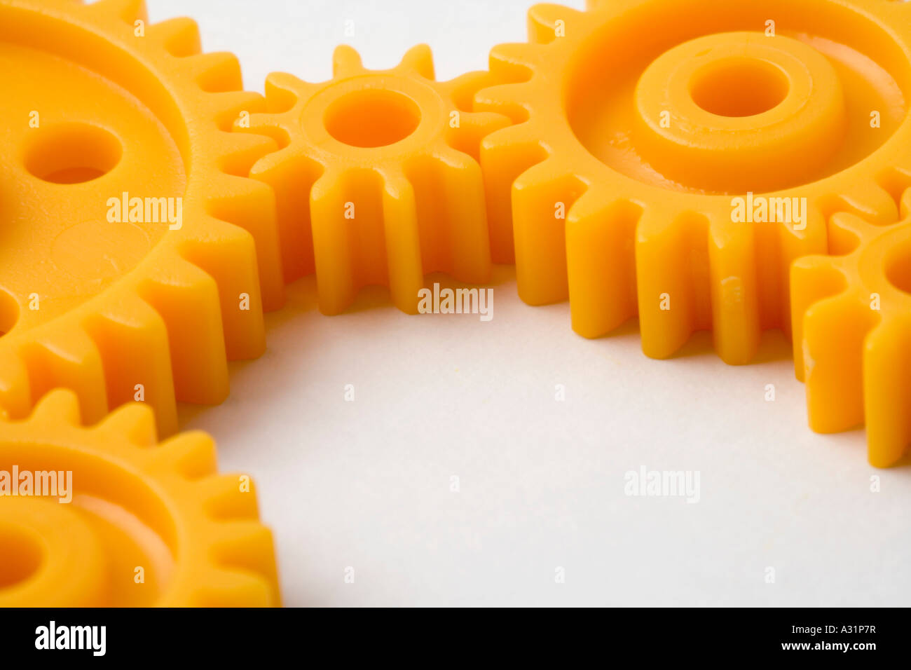 Five orange cogs interlocked Stock Photo - Alamy