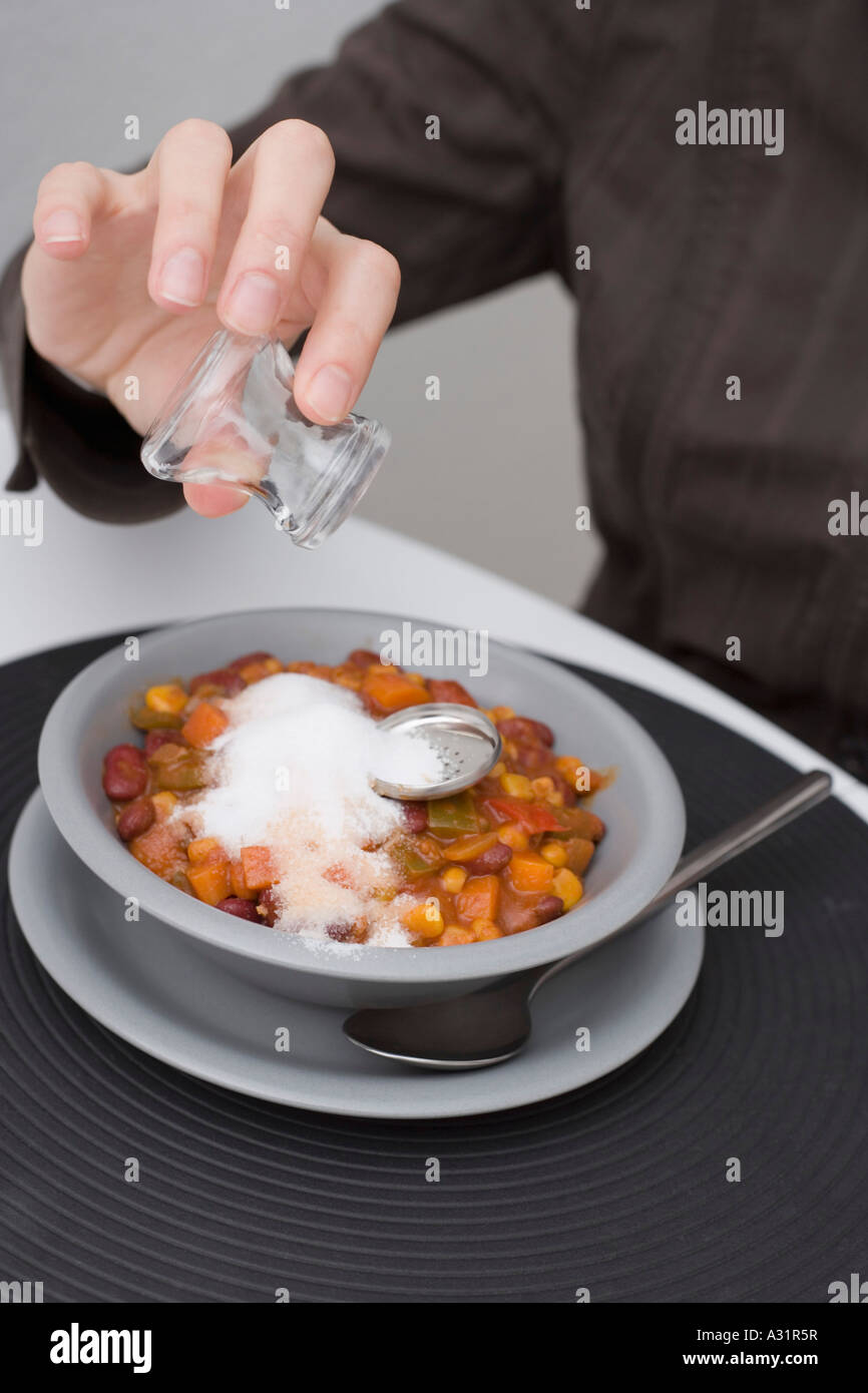 Man holding empty salt shaker above ruined meal Stock Photo - Alamy