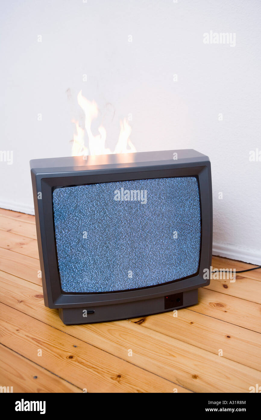Flames behind television Stock Photo - Alamy