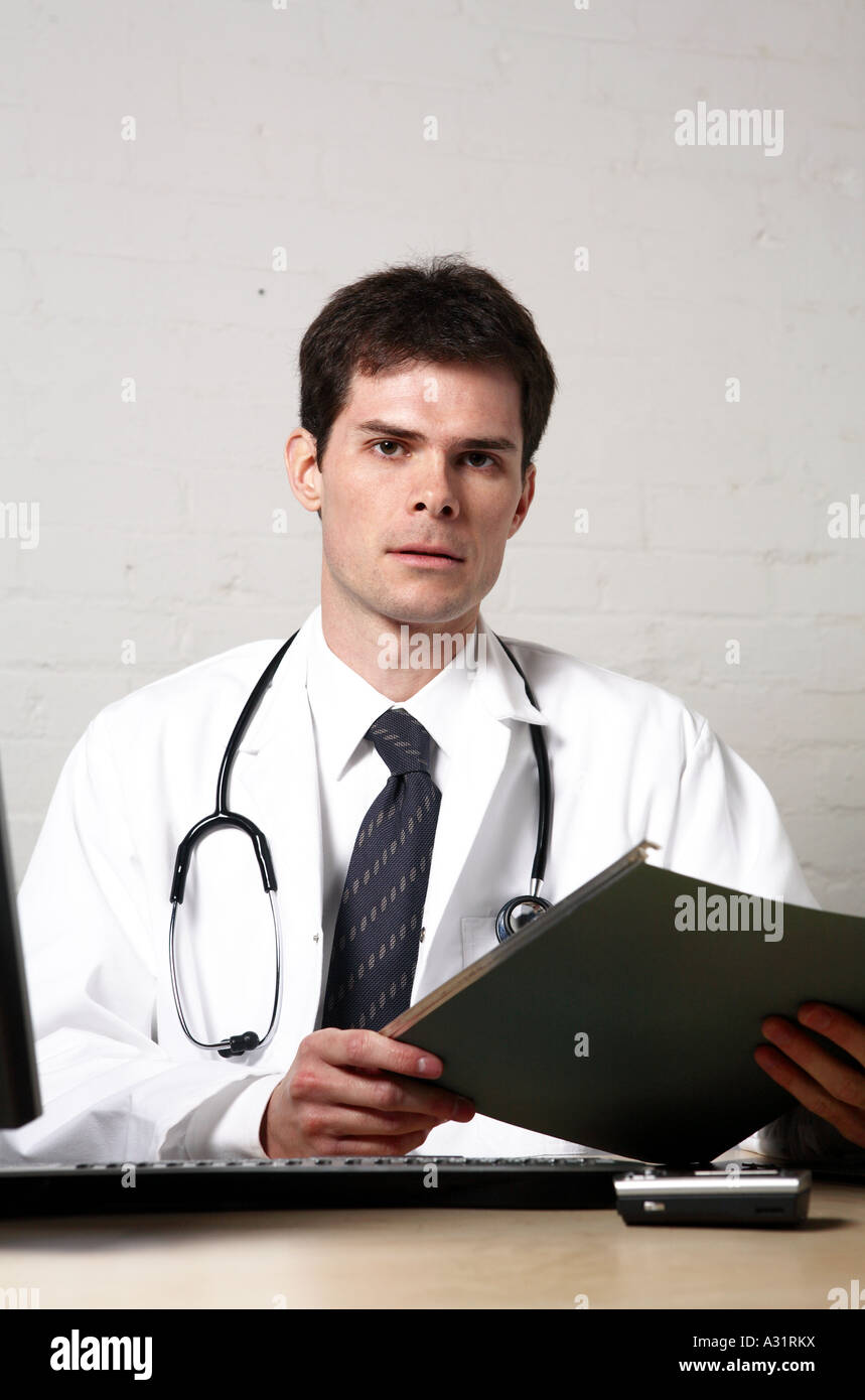 Doctor at office desk Stock Photo - Alamy