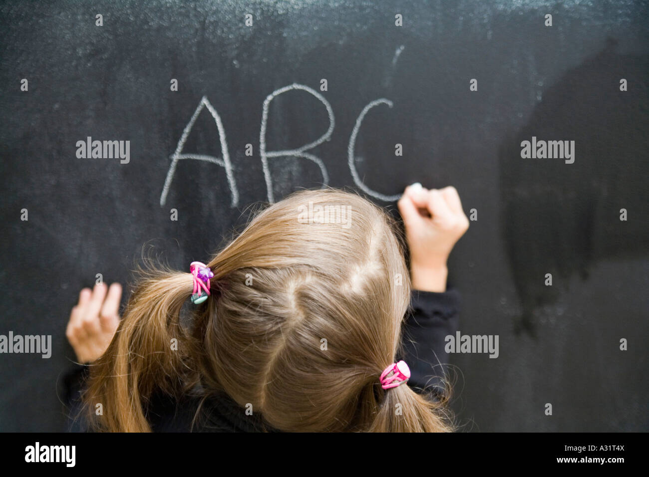 Young child writing on chalkboard Stock Photo - Alamy