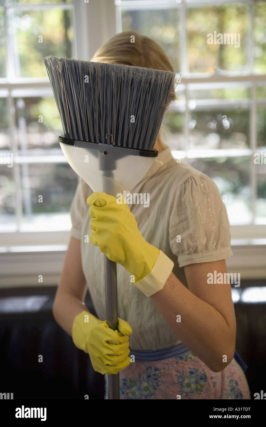 Woman holding broom in front of her face Stock Photo - Alamy