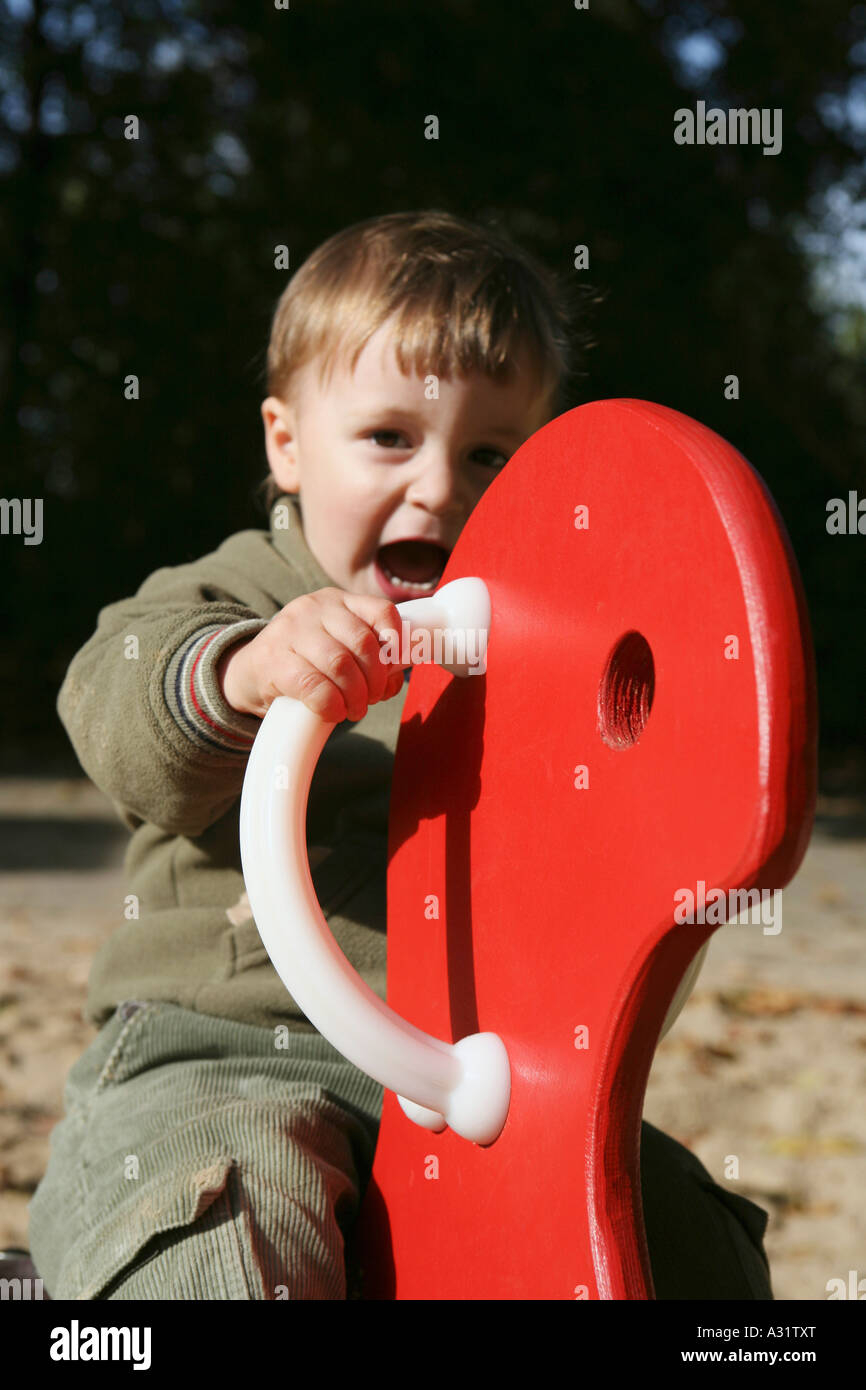Young boy playing on spring ride in playground Stock Photo - Alamy