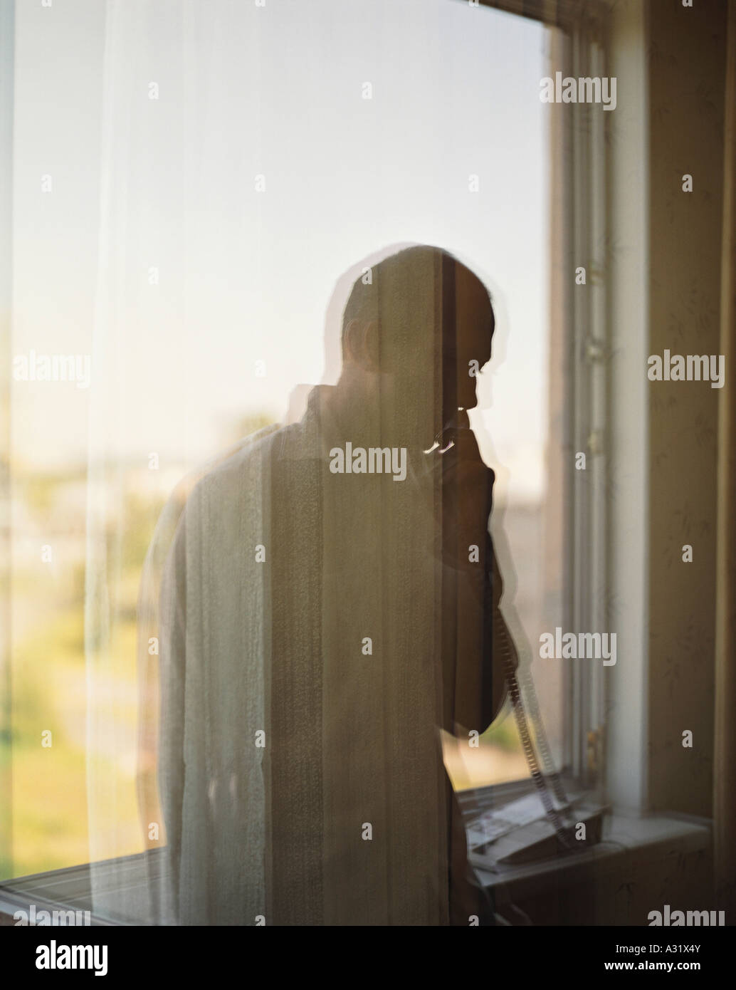 View through window of a businessman using a telephone Stock Photo - Alamy