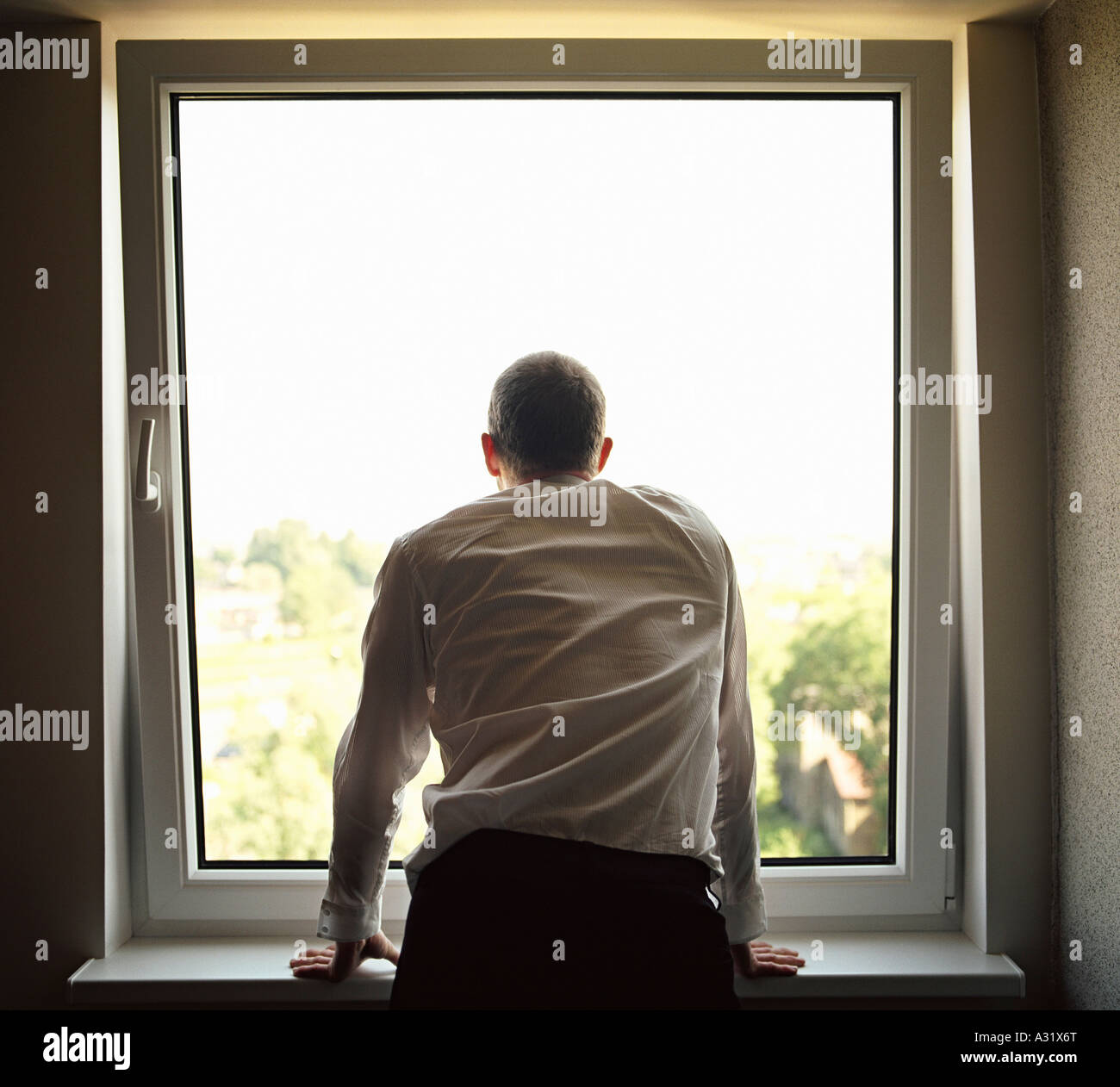Businessman looking out a window Stock Photo - Alamy