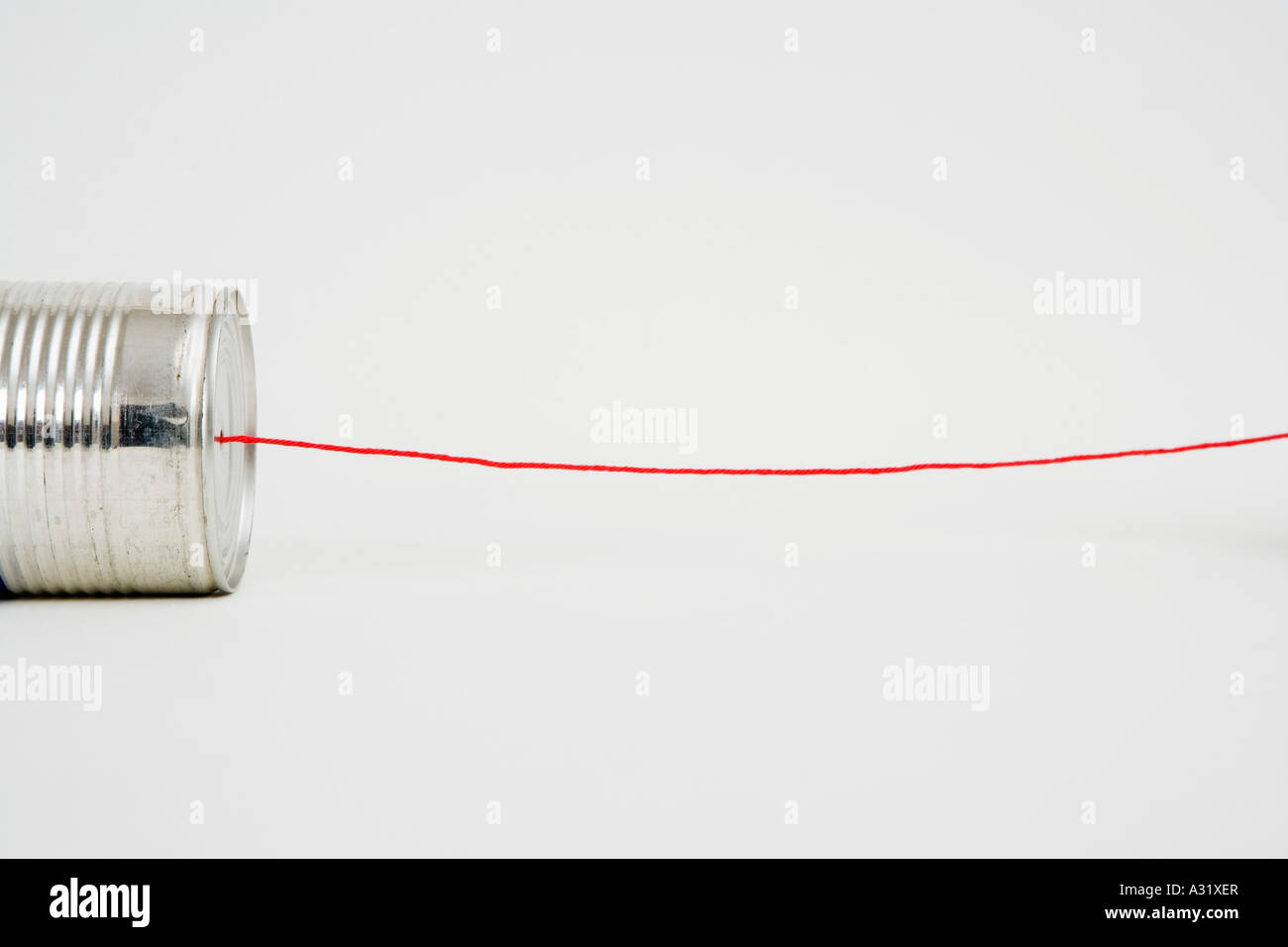 Red string attached to tin can Stock Photo - Alamy