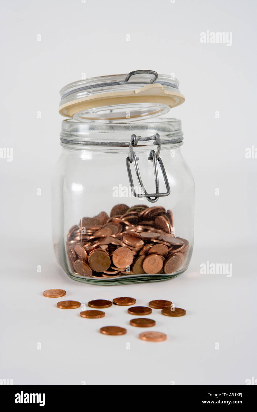 Loose change in front of jar of copper coins Stock Photo - Alamy