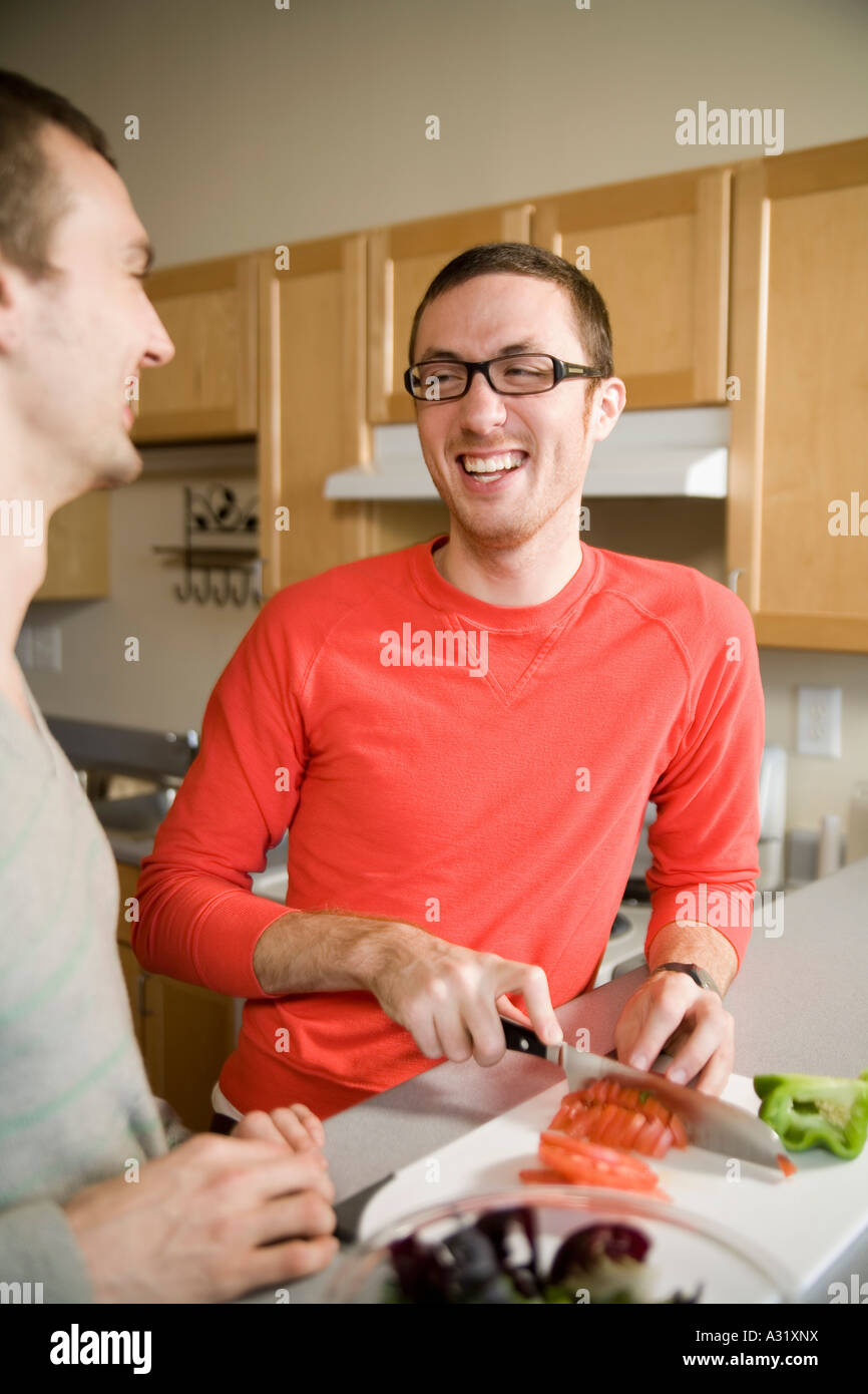 Two man preparing food together in kitchen and laughing Stock Photo - Alamy