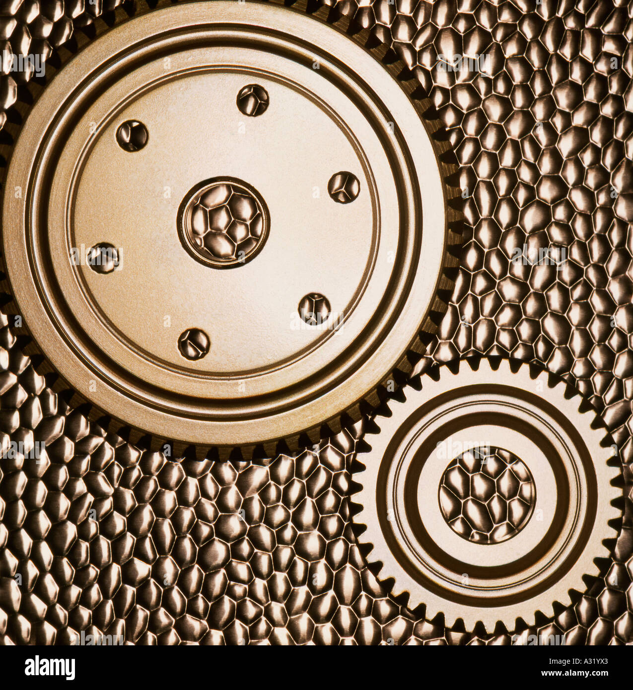 Two interlocking gold coloured car gearbox cogs Stock Photo - Alamy