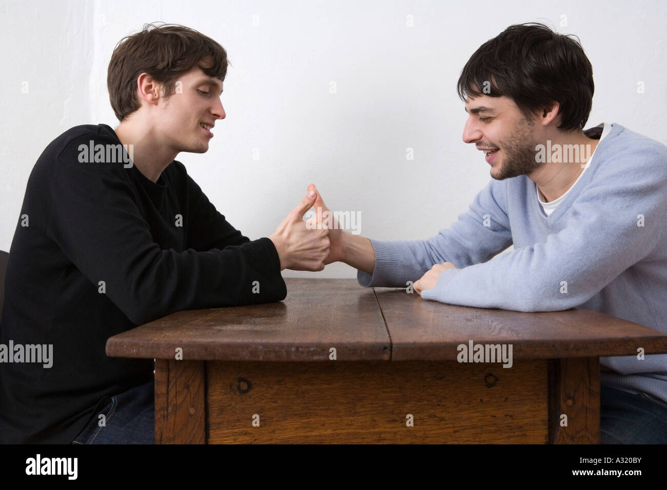 Two young men playing game and laughing at table Stock Photo - Alamy