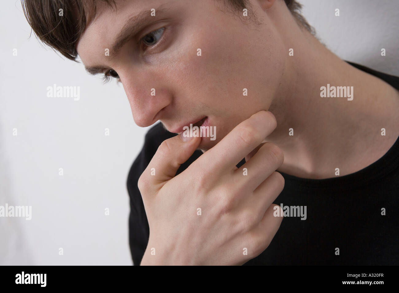 Young man biting his nails Stock Photo - Alamy