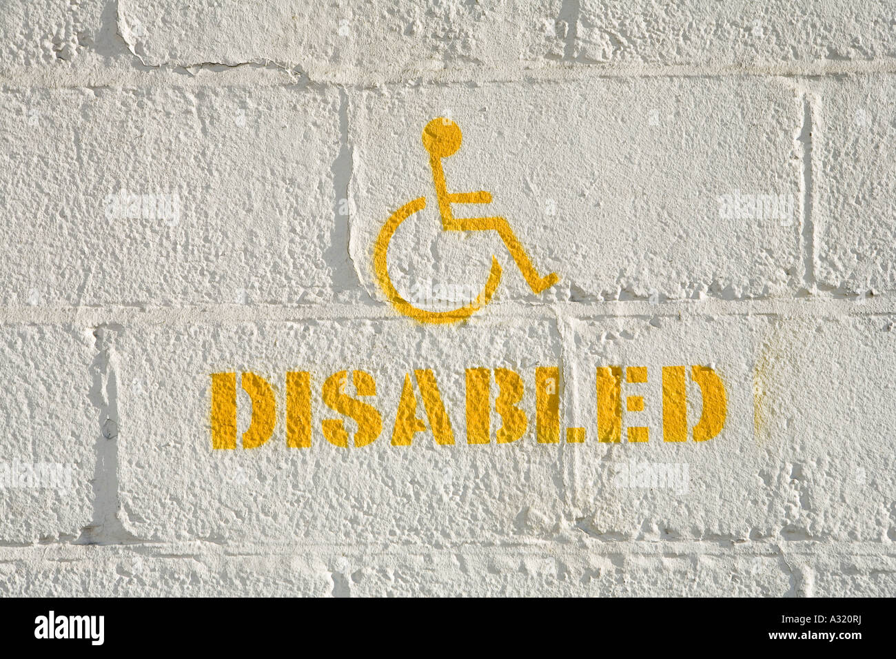 Disabled parking sign on a brick wall Stock Photo - Alamy