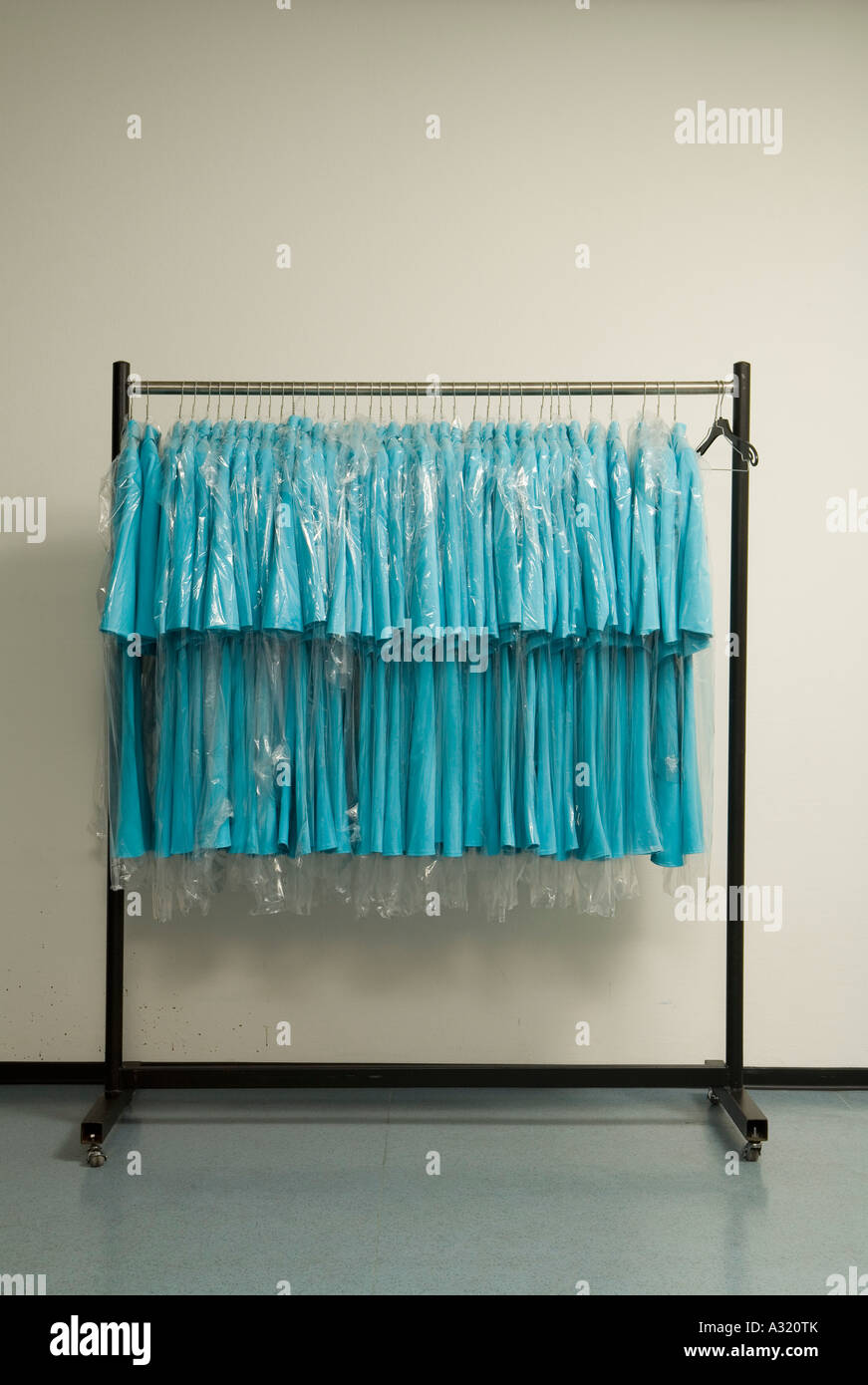 Row of blue shirts hanging on clothes rack Stock Photo - Alamy