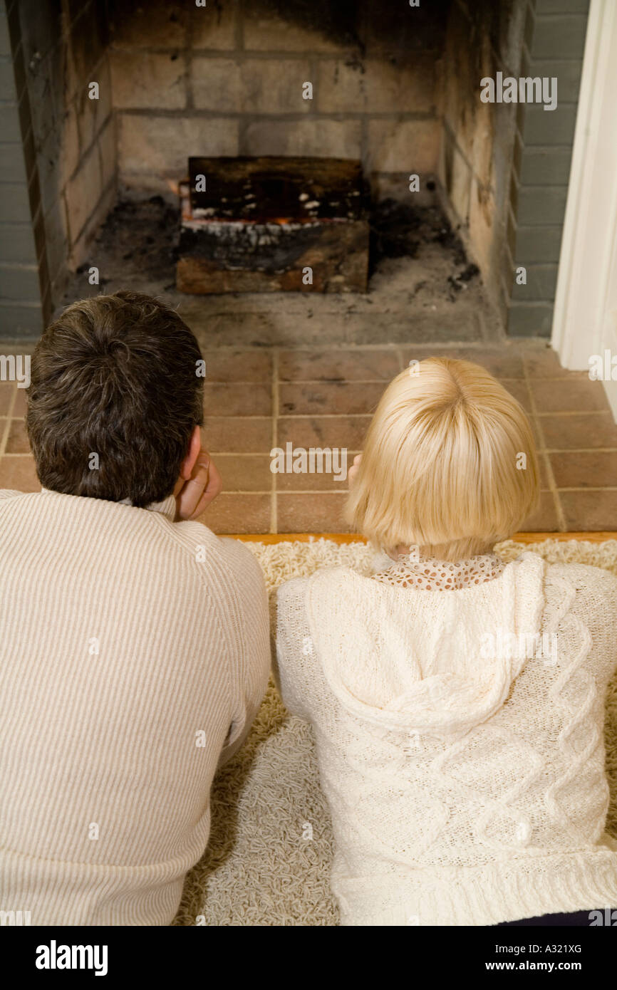 Young couple lying down in front of an open fire together Stock Photo ...