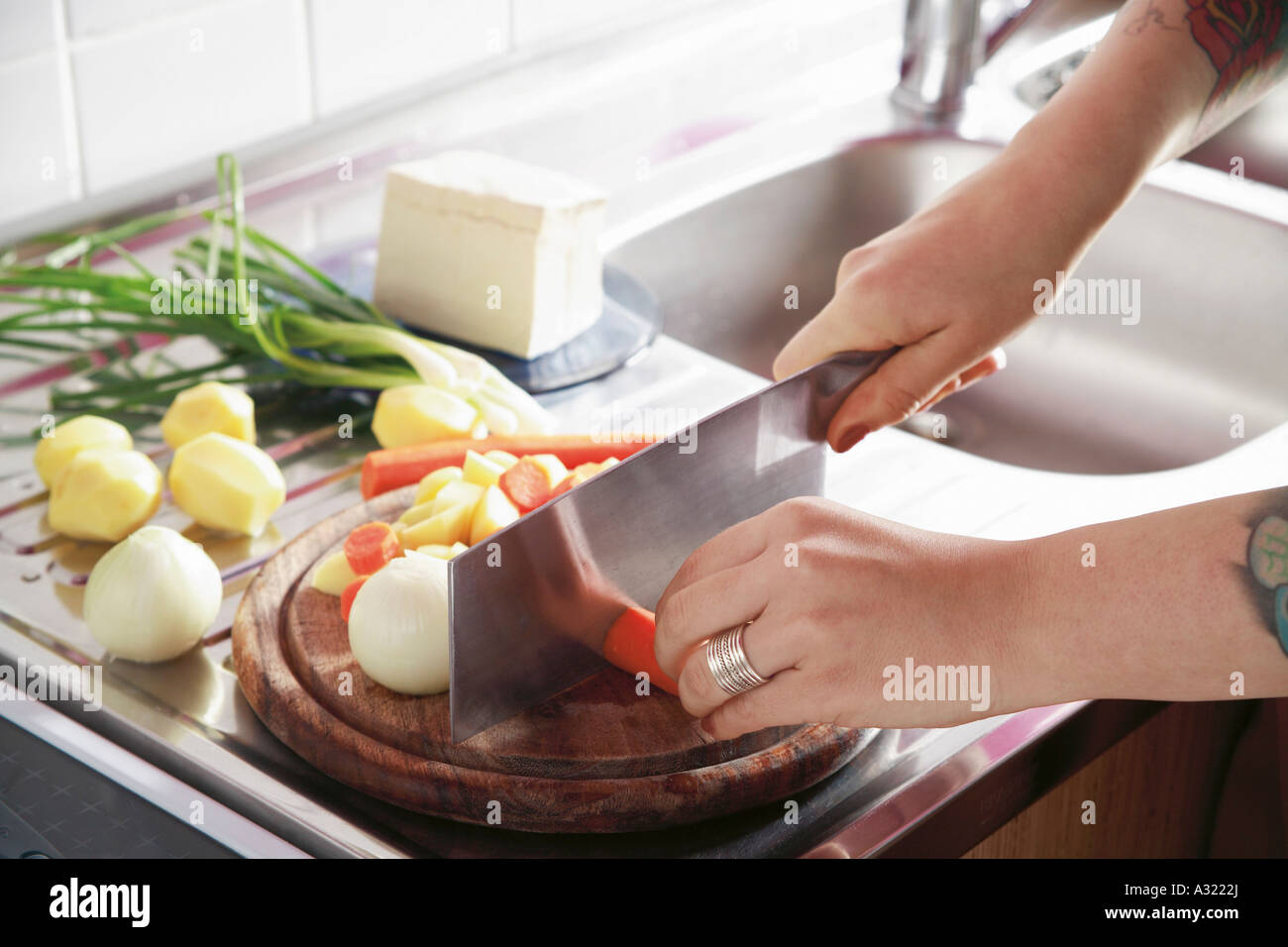 Woman chopping vegetables on kitchen sink Stock Photo - Alamy