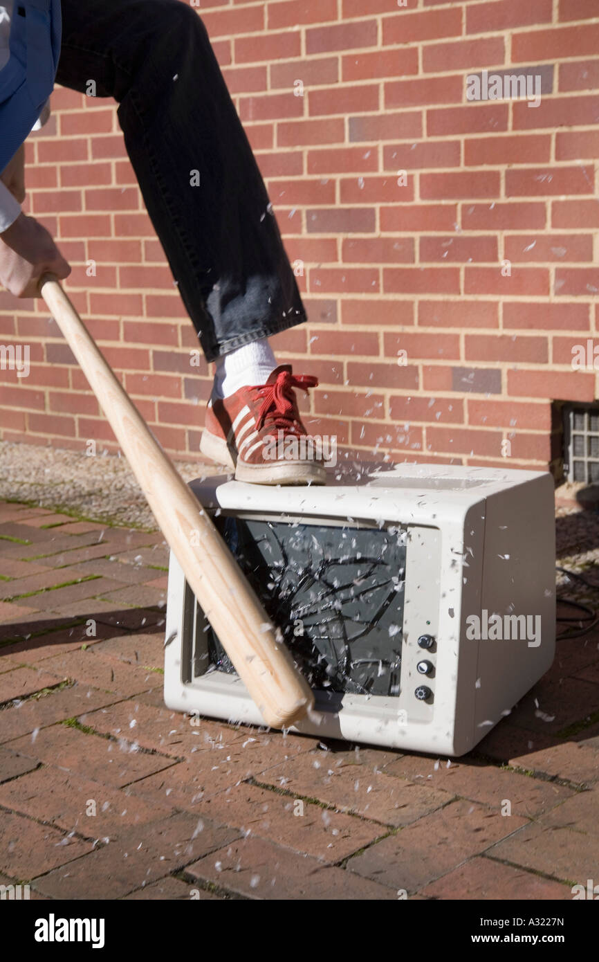 Man smashing a monitor with a baseball bat Stock Photo - Alamy