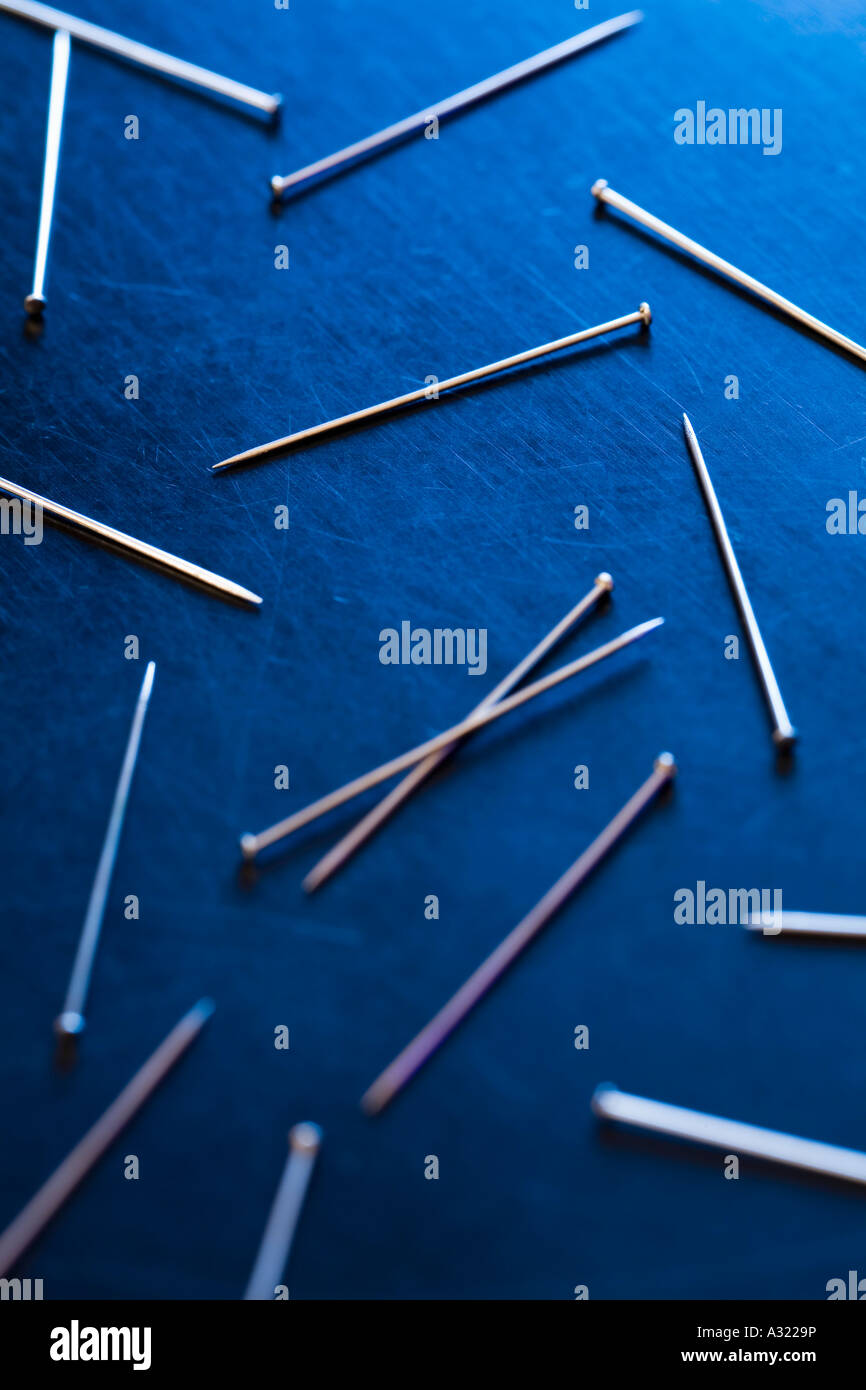 Silver pins on a desk Stock Photo - Alamy