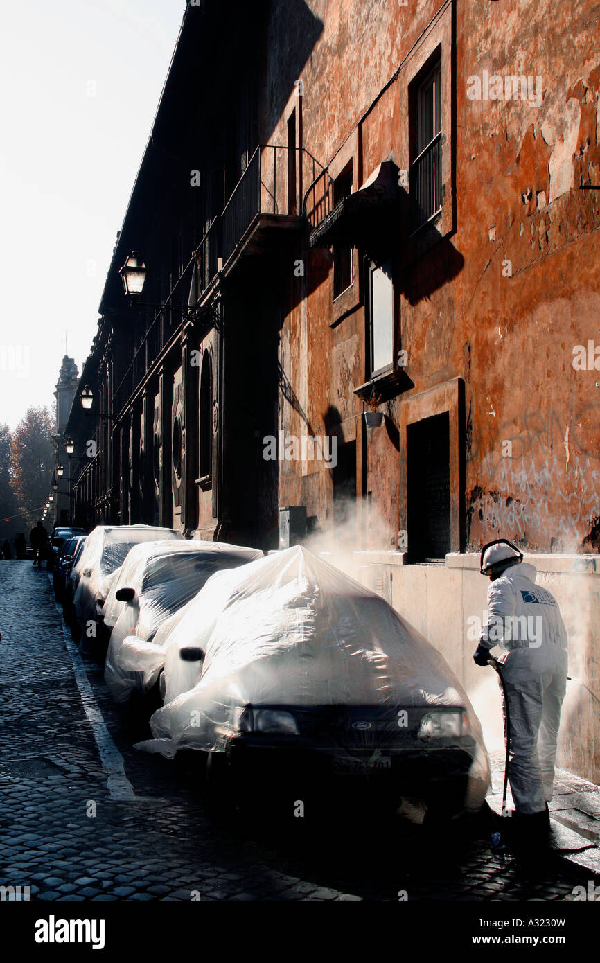 Work man pressure spraying to remove graffiti in the Trastevere area of ...