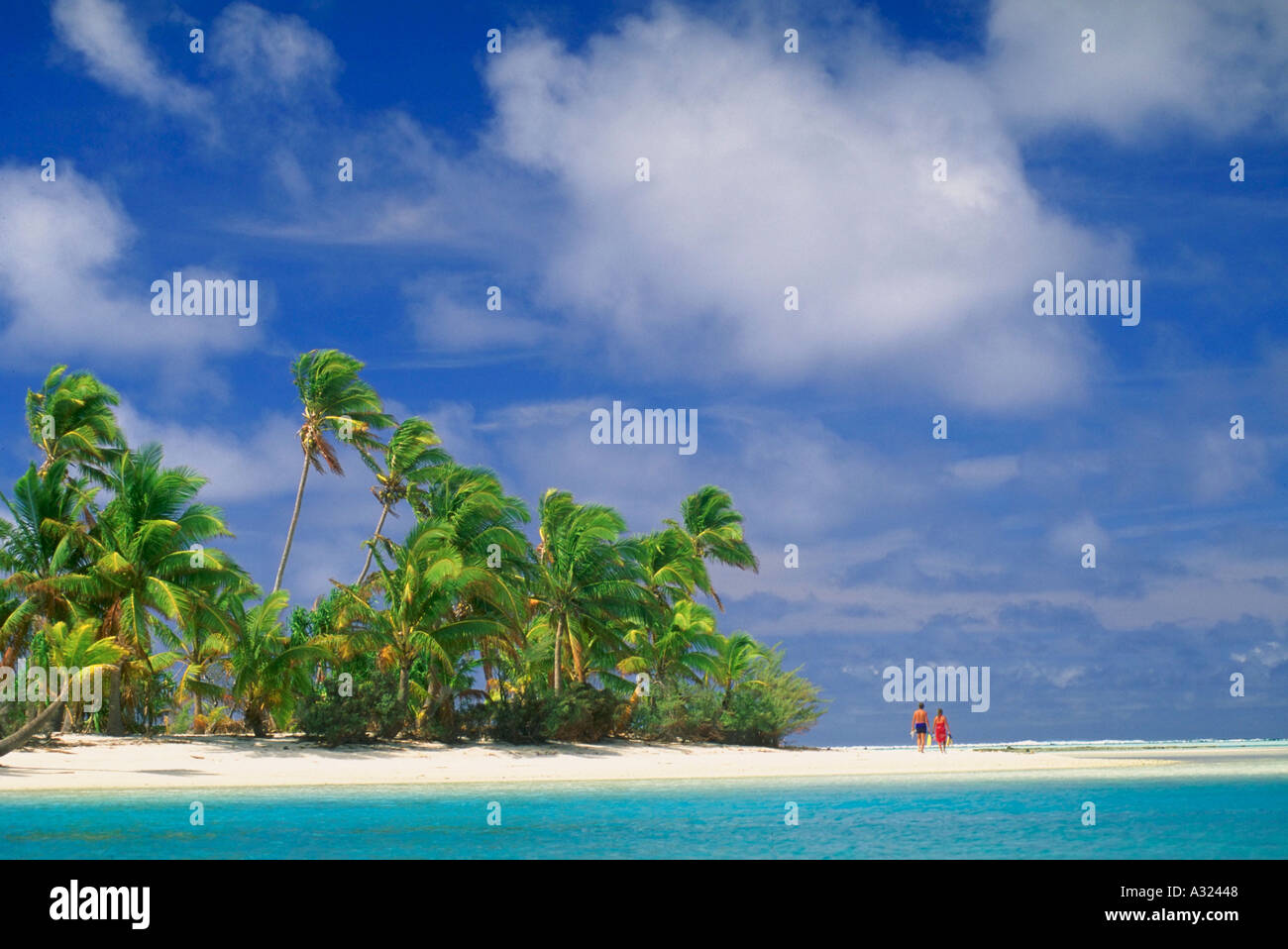 Couple walking on the beach with blue sky and ocean Cook Islands Stock ...